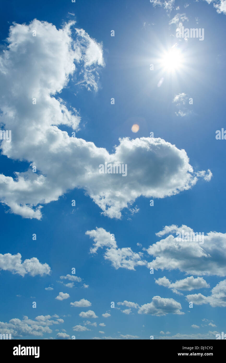 Cumulus clouds and the sparkling sun on the blue summer sky Stock Photo ...