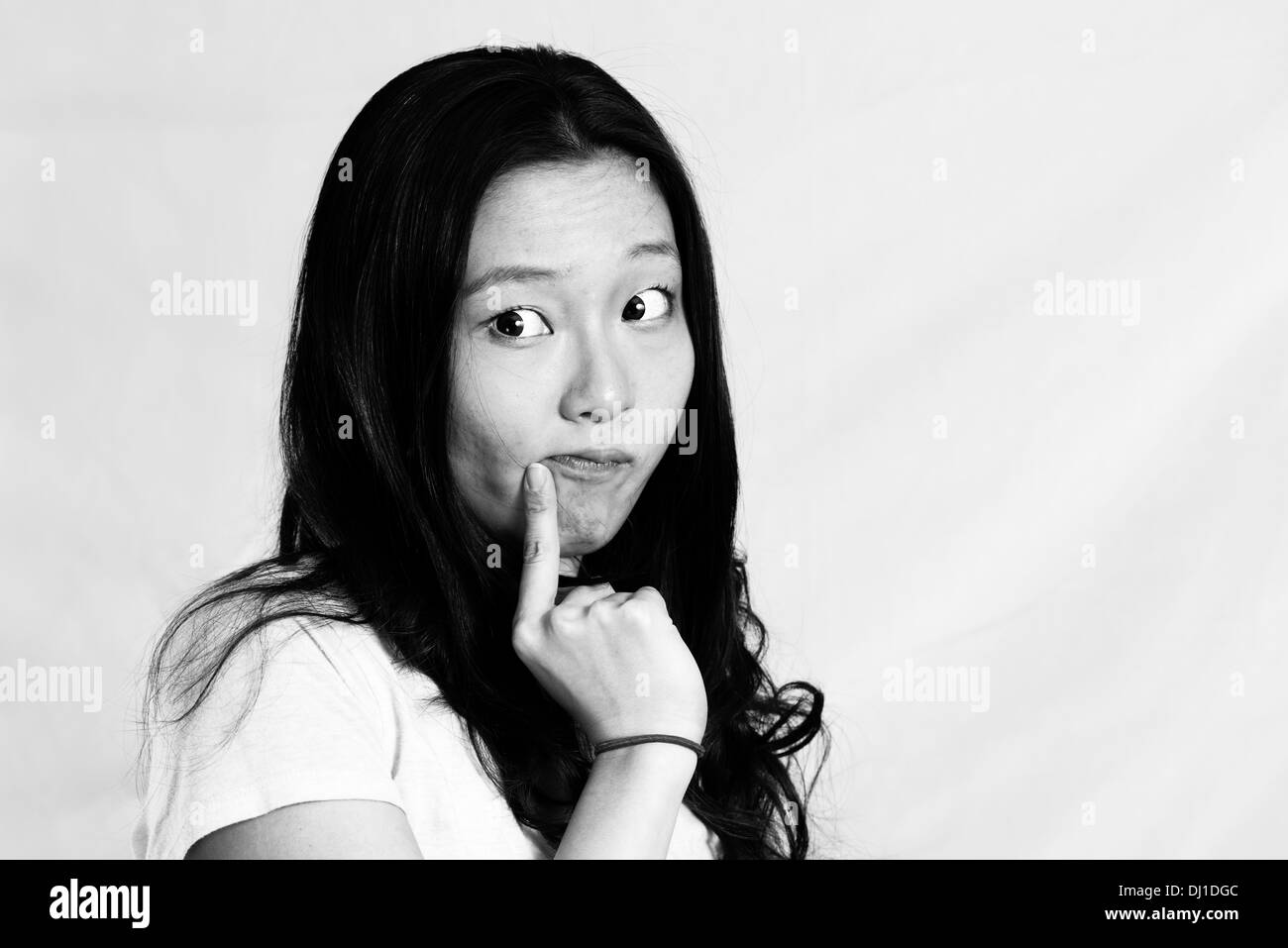 Portrait of cute young woman with cute pose poking face, black and ...