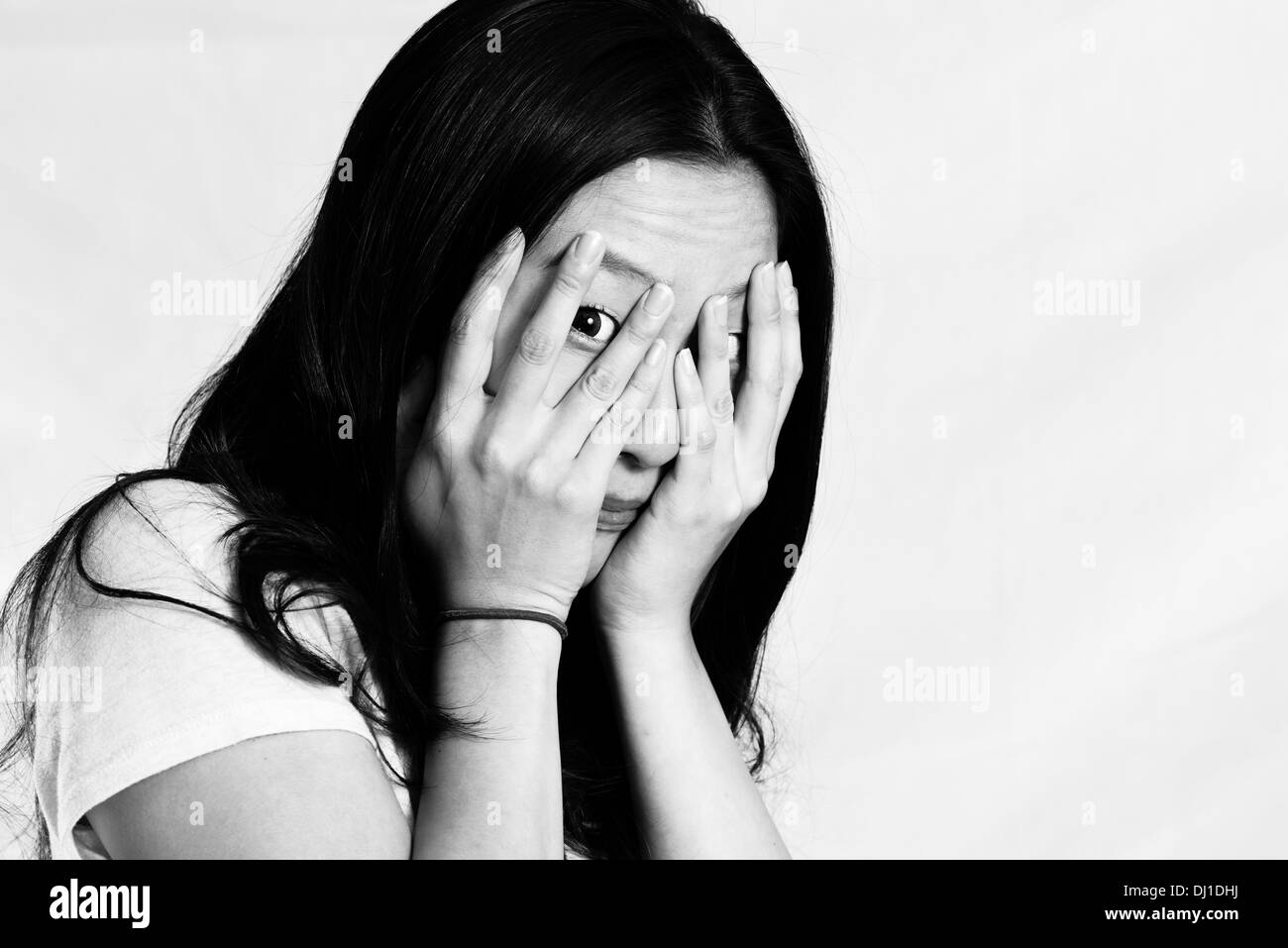 Portrait of cute young woman covering her face, black and white style ...