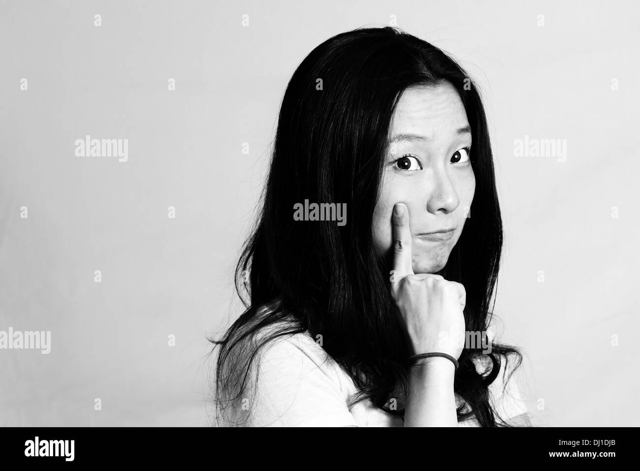 Portrait of cute young woman with cute pose poking face, black and ...