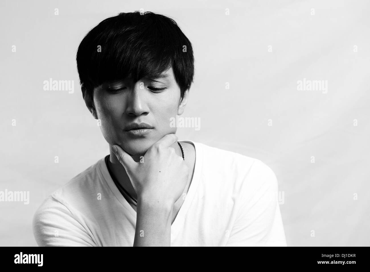 Portrait of handsome young man looking deep in thought, black and white ...