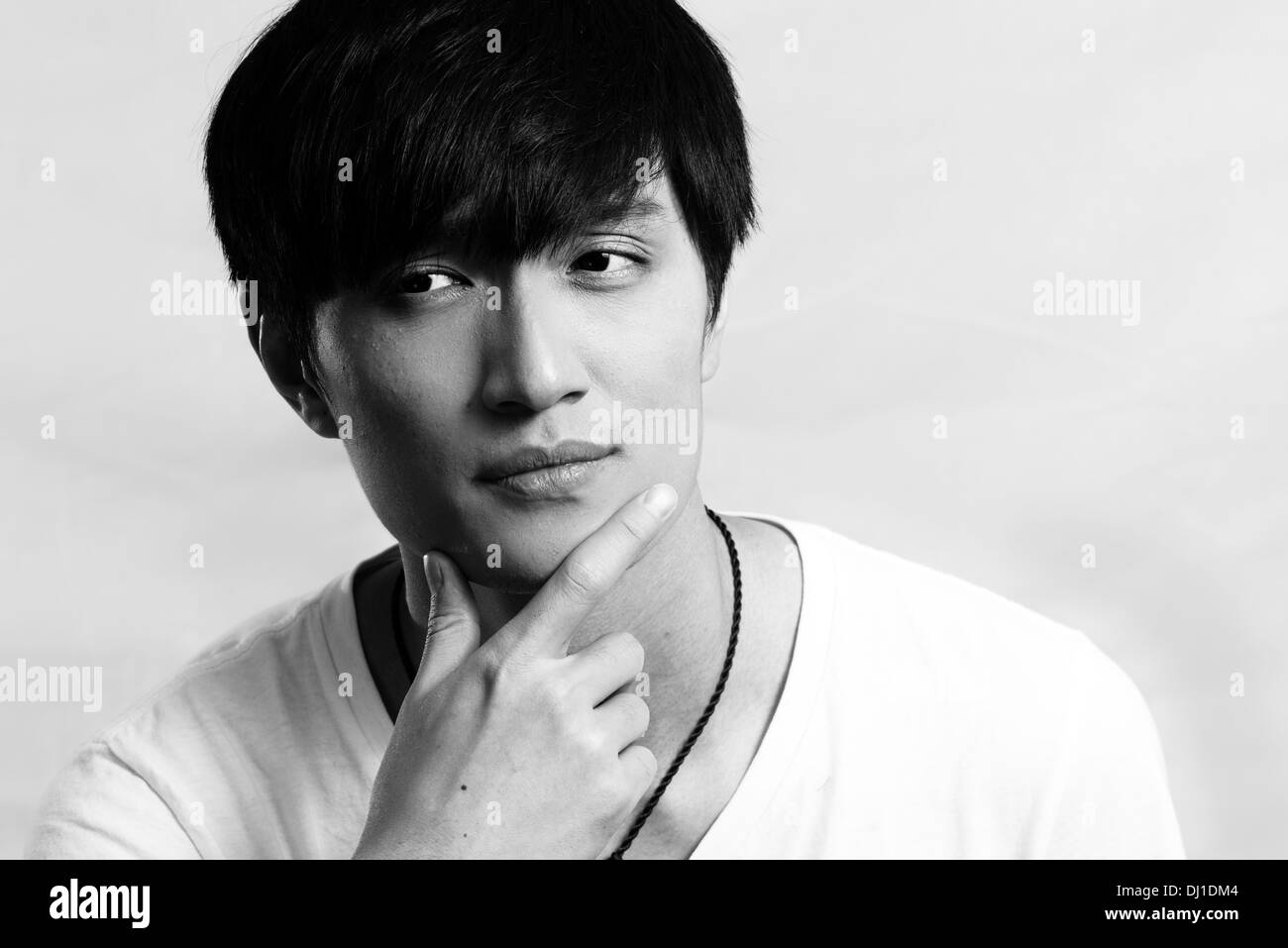 Portrait of handsome young man looking deep in thought, black and white ...