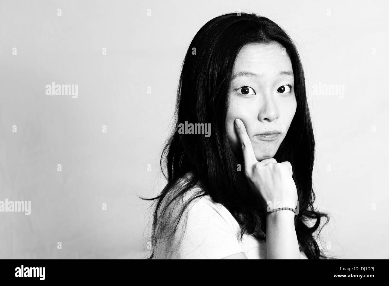 Portrait of cute young woman with cute pose poking face, black and ...