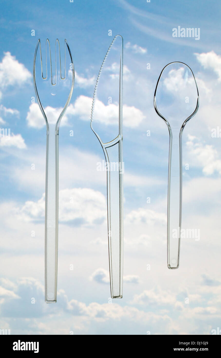 transparent plastic cutlery on a background of sky and clouds. Light ...