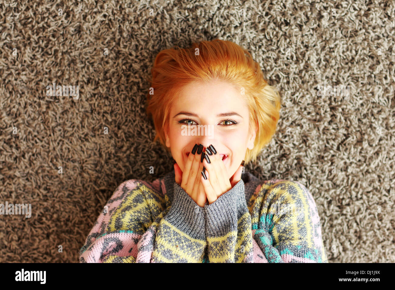 Young woman lying on carpet at home hi-res stock photography and images ...