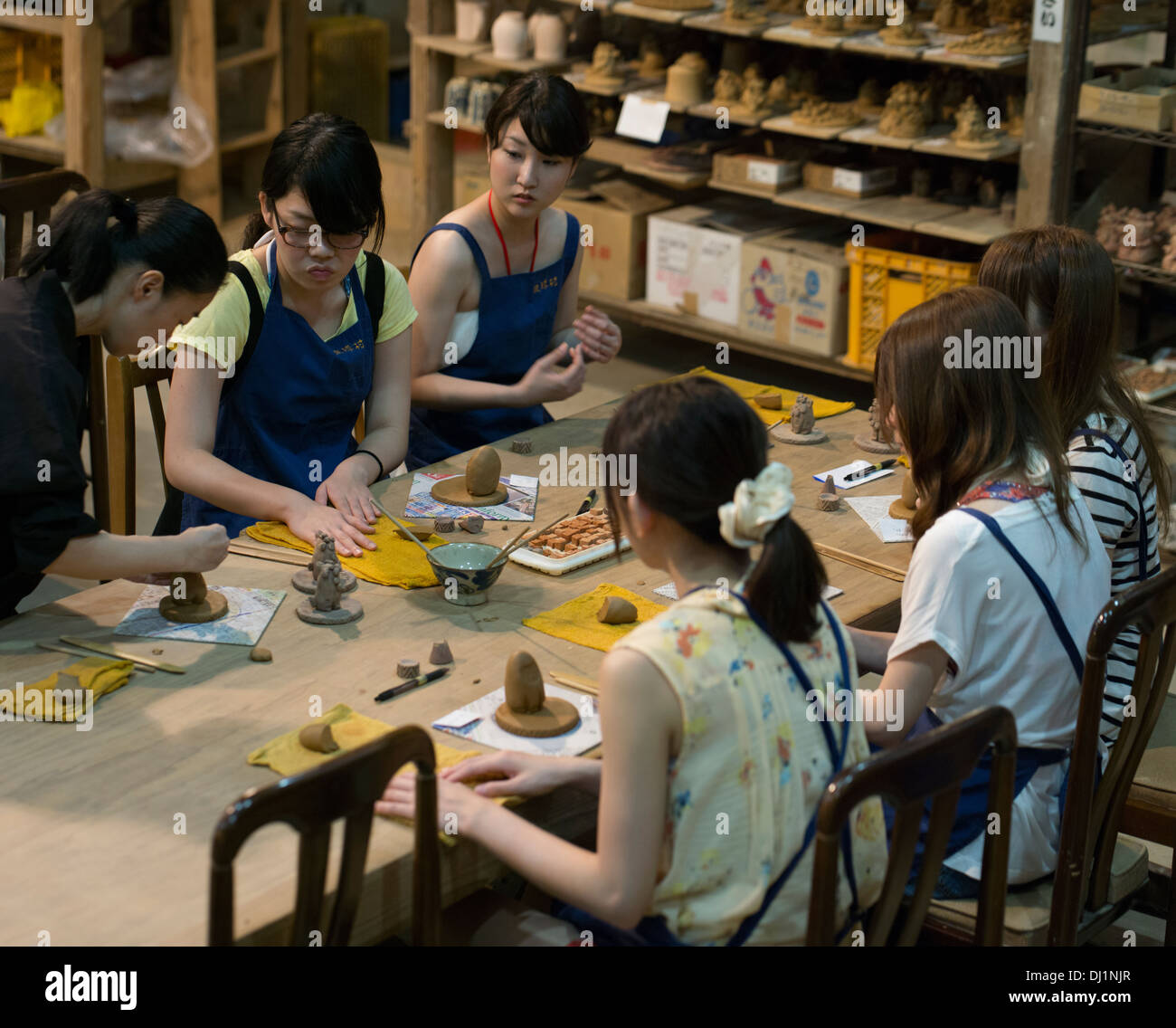 Tourists learning to make shisa at Ryukyu Mura Stock Photo - Alamy