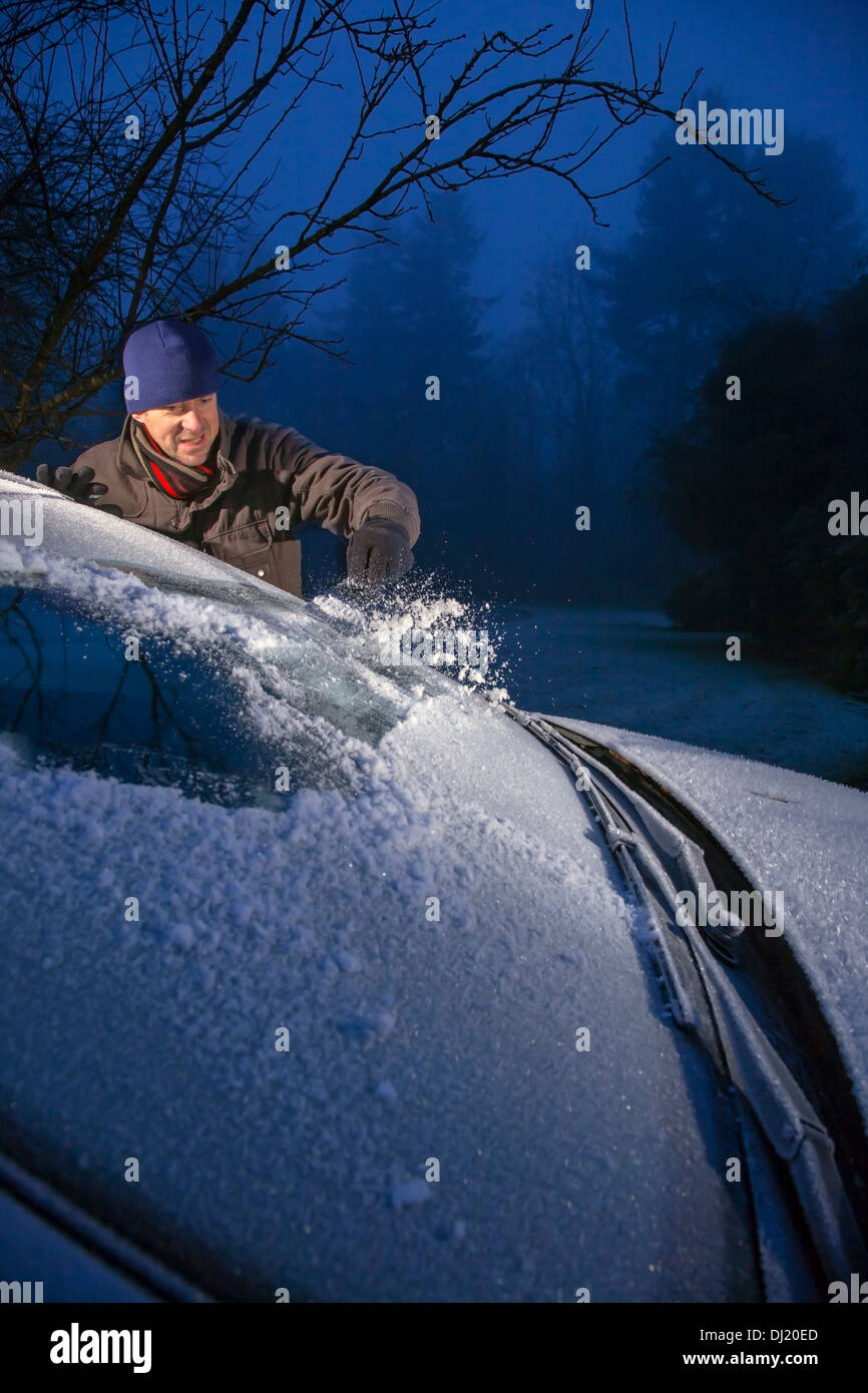 Man scraping ice from a frost covered car windscreen Stock Photo - Alamy
