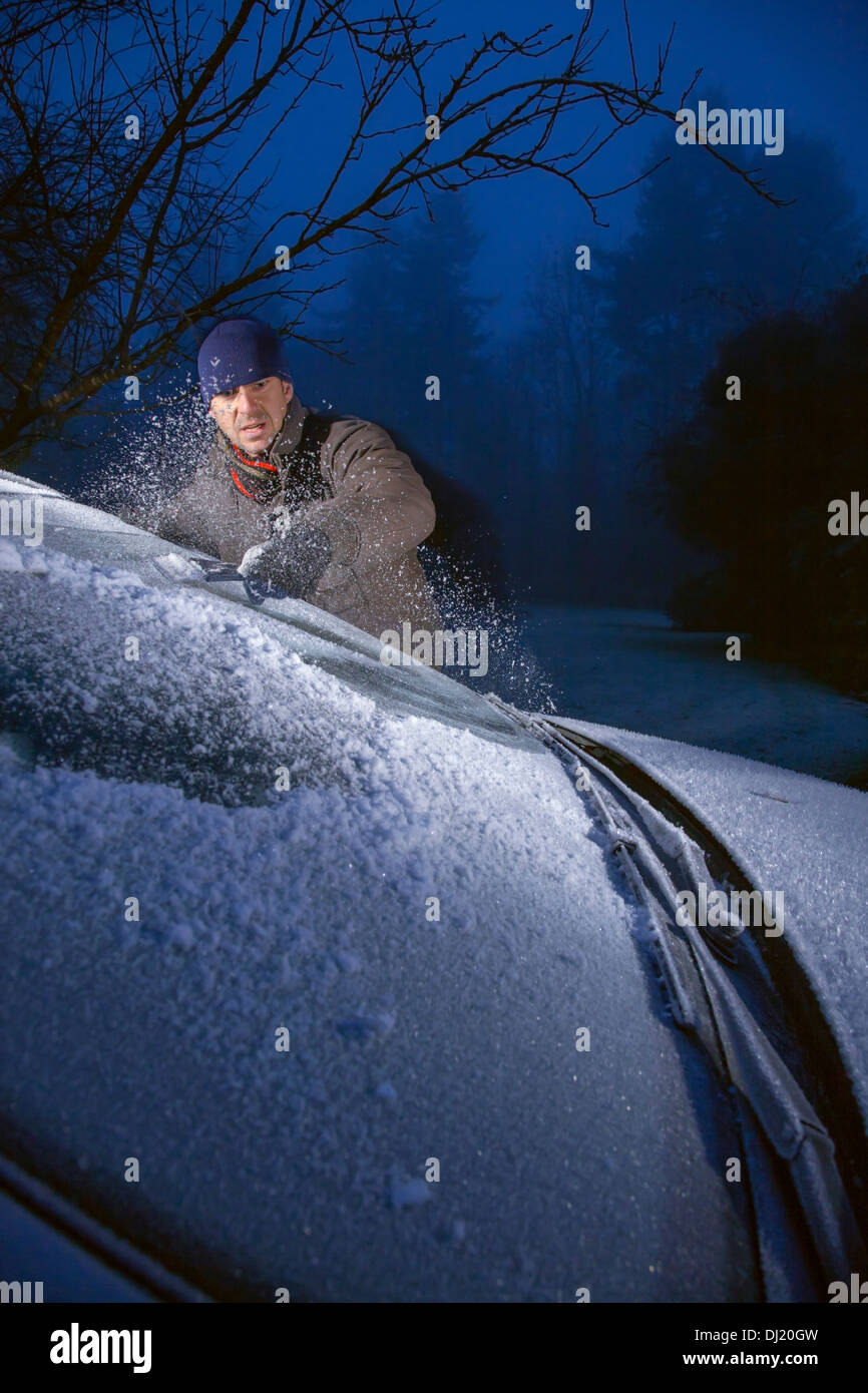 Man scraping ice from a frost covered car windscreen Stock Photo - Alamy