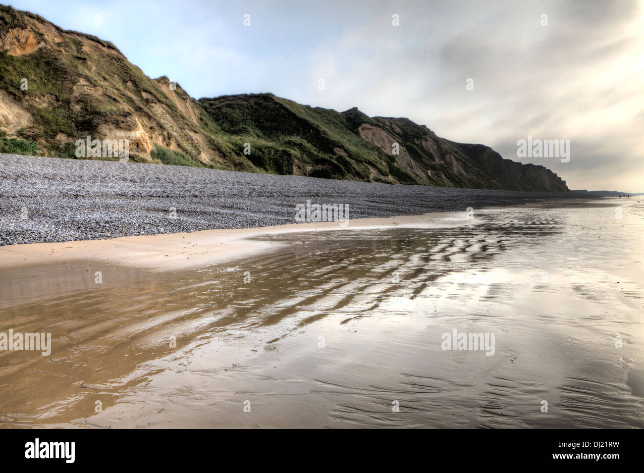 Wet sand ripples and tall cliffs Stock Photo - Alamy