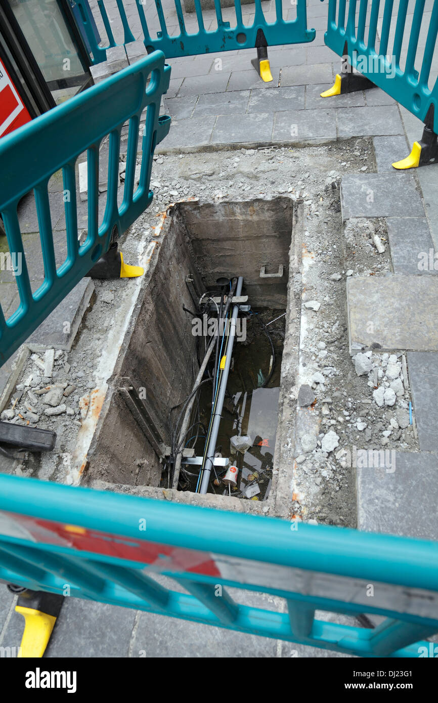 An open manhole for access to utility services on a pavement, Scotland ...