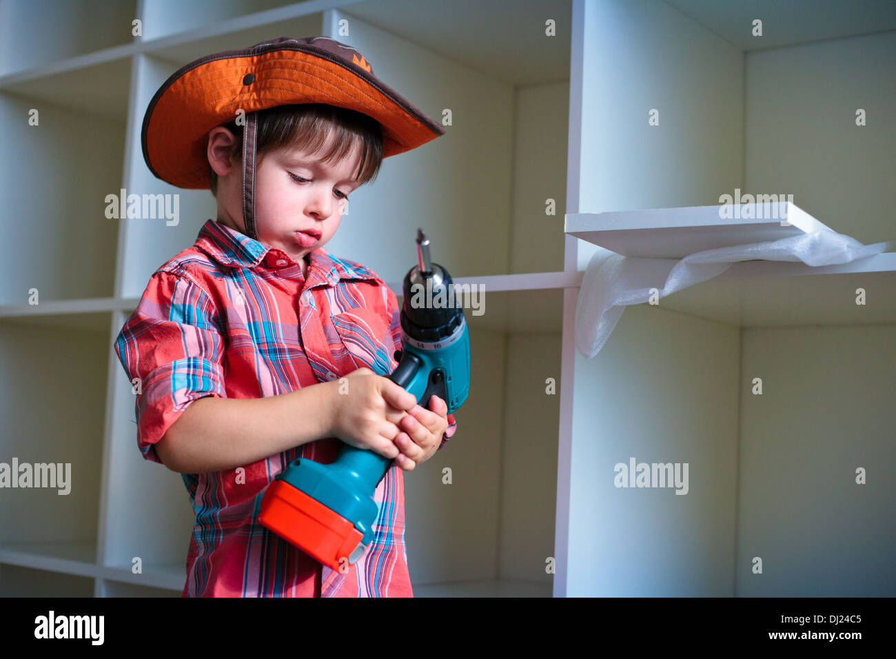 Cute little boy using an electric screwdriver Stock Photo - Alamy