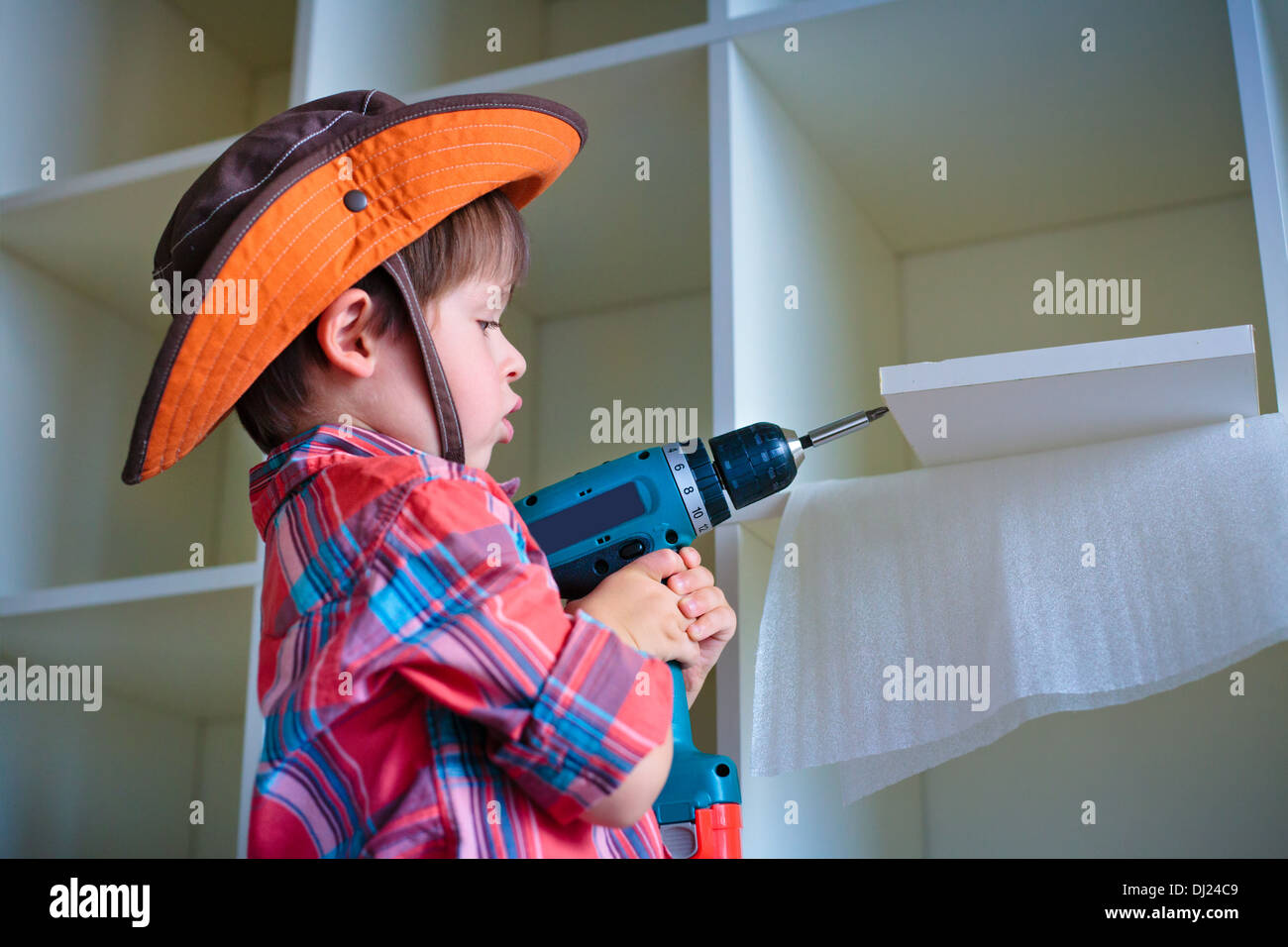 Cute little boy using an electric screwdriver Stock Photo - Alamy