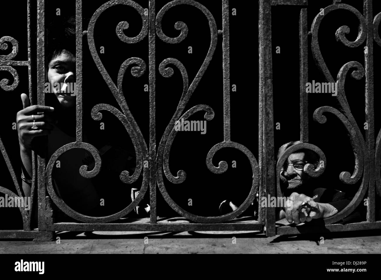 Cuban women seen in the shadow behind the window grill during a hot ...