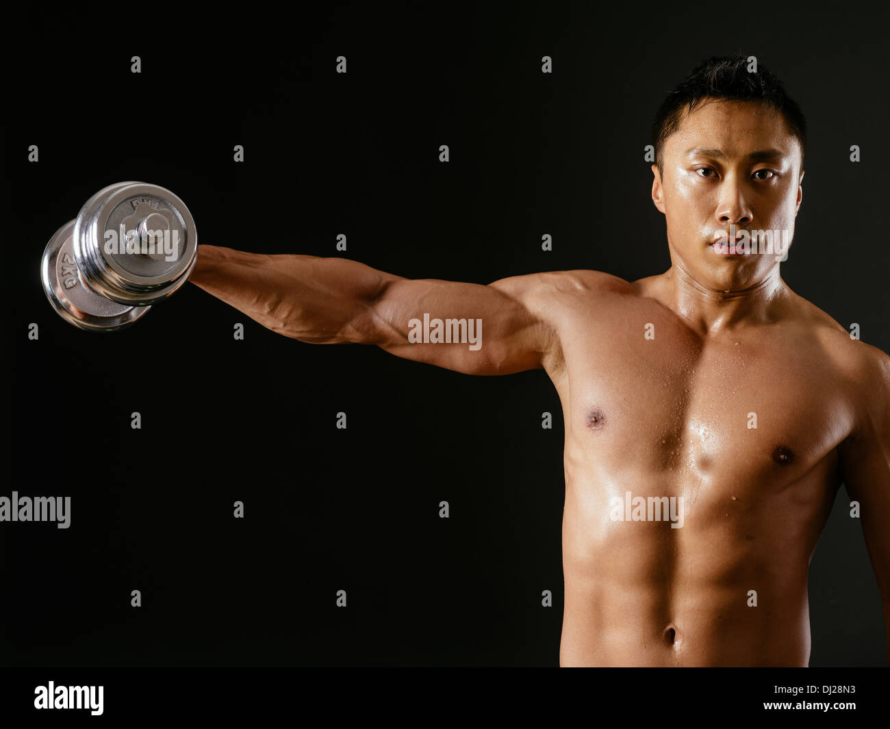 Photo of an Asian male exercising with dumbbells and doing shoulder ...