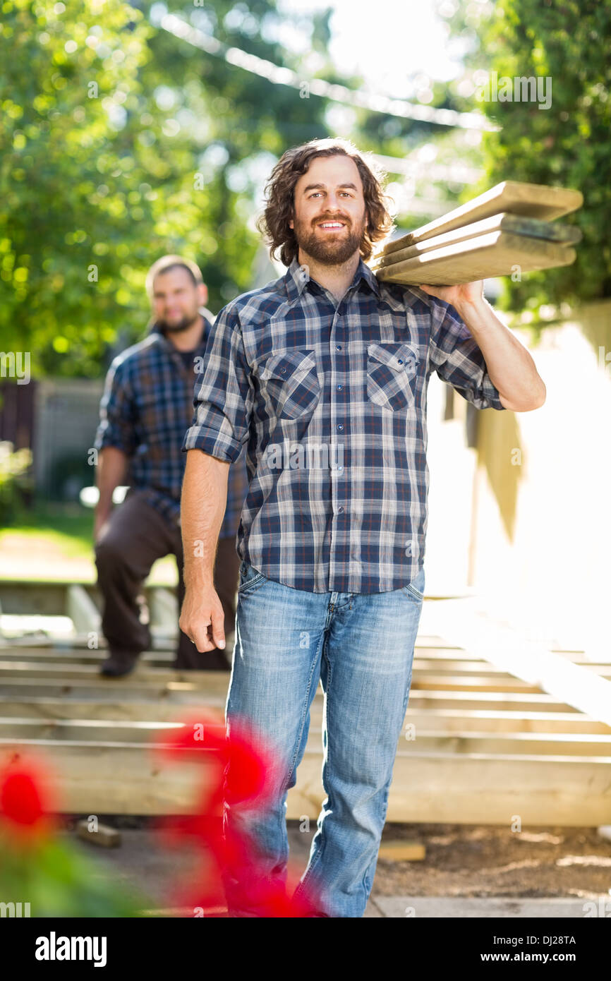 Carpenter And Coworker Carrying Wooden Planks At Construction Si Stock ...