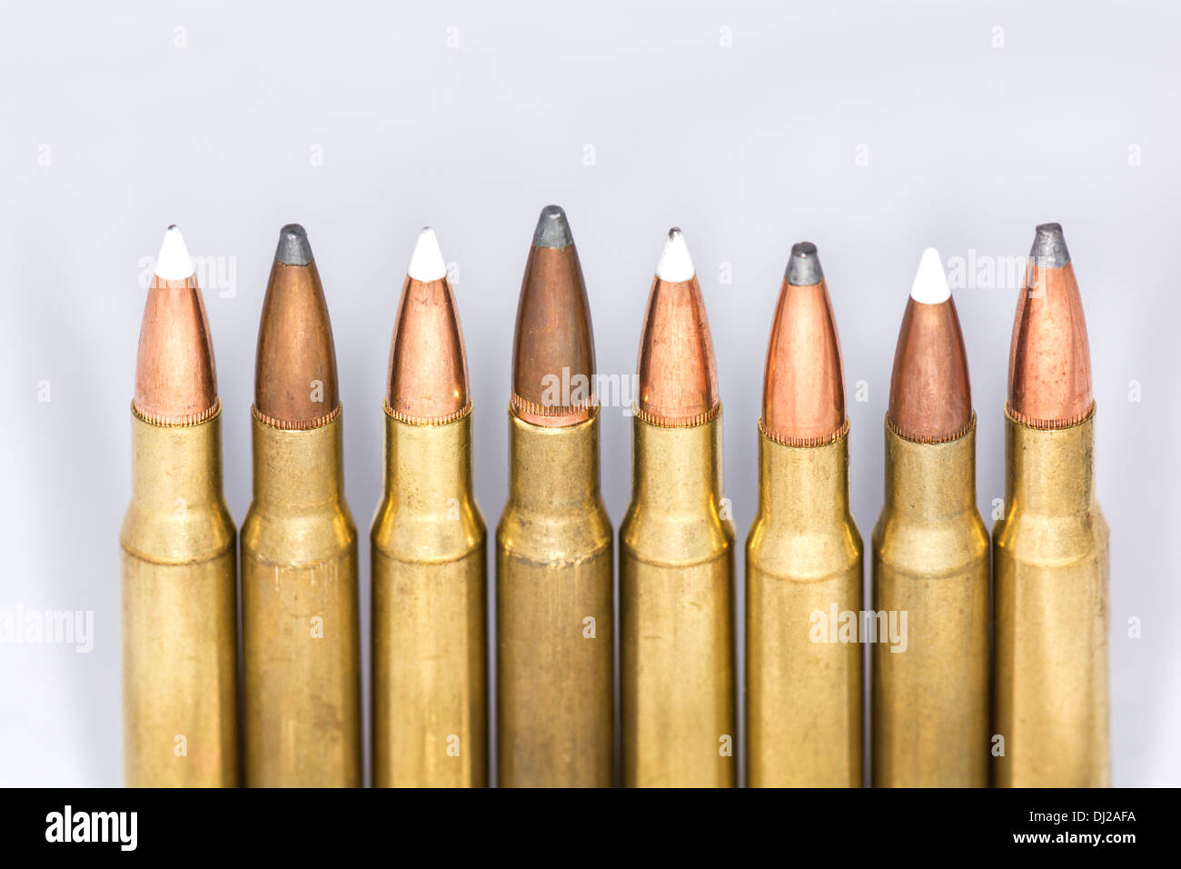 Tips of a few rifle bullets lined up in a row on white background Stock ...