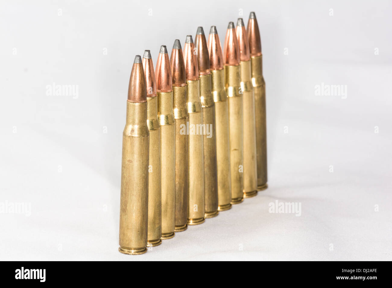 A few rifle bullets lined up in a row on white background Stock Photo ...