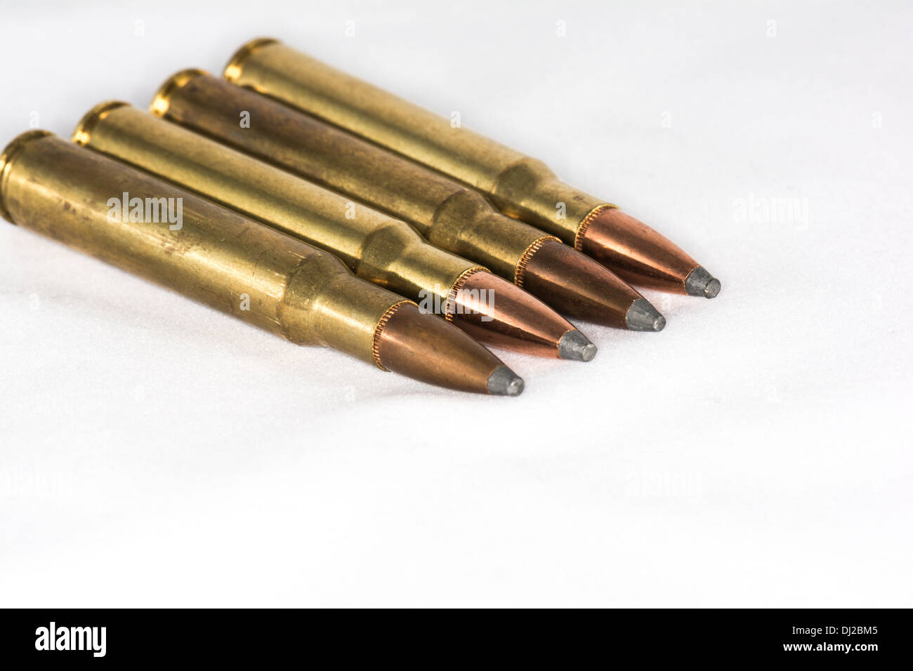 A few rifle bullets lined up in a row on white background Stock Photo ...