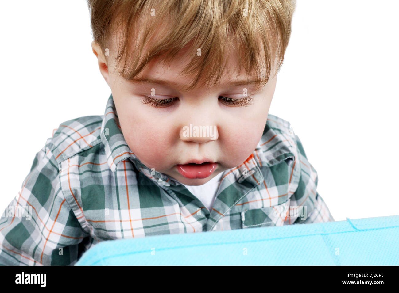 Cute little blond toddler boy looking into a blue box for discovery ...