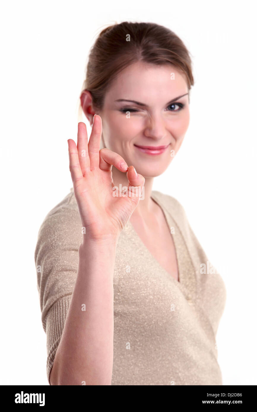 Beautiful young woman giving the ok sign and winking Stock Photo - Alamy