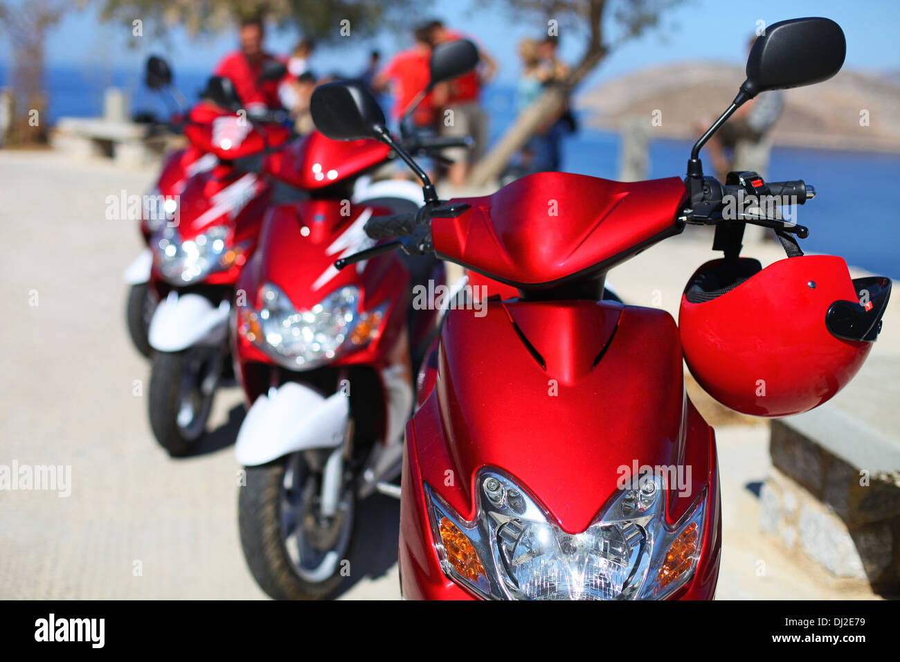 Scooters in row parked along road at seaside Stock Photo - Alamy