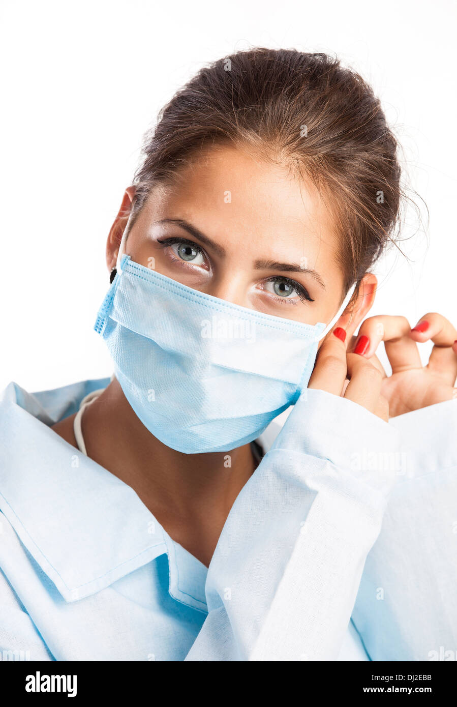Closeup portrait of a young doctor wearing a mask over white background ...
