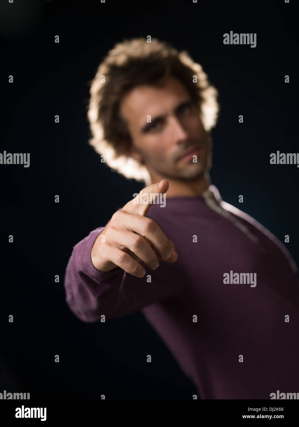 man in purple sweater gestures pointing finger Stock Photo - Alamy