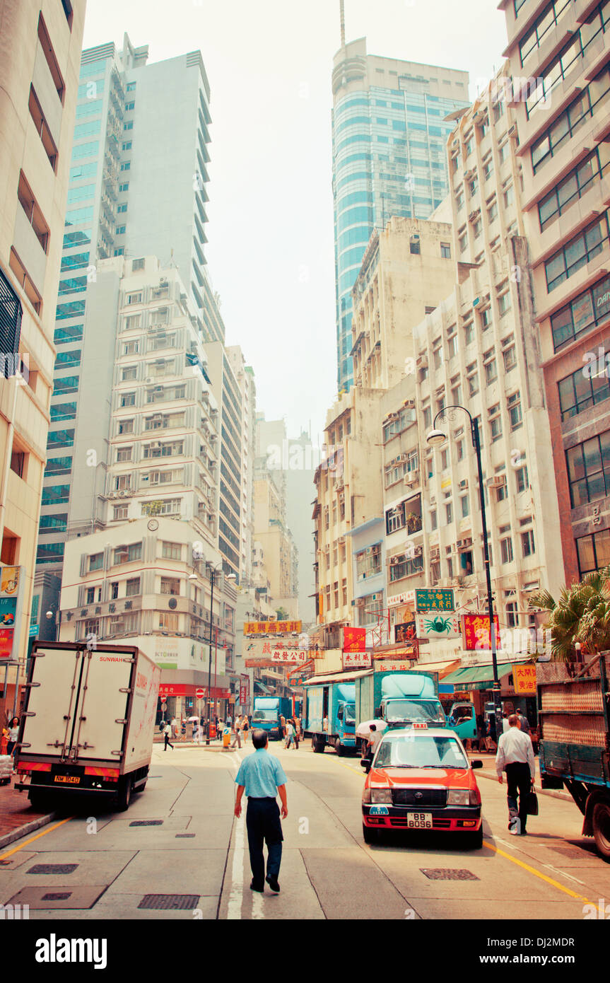 Hong Kong downtown street view with pedestrians, trams, taxis, shops ...