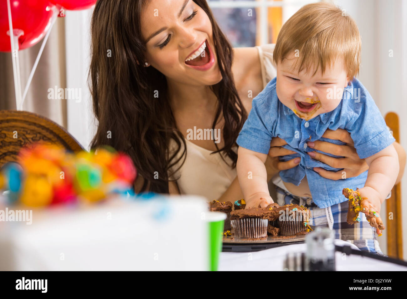 Mother Holding Boy With Messy Hands Covered With Cake Icing Stock Photo ...