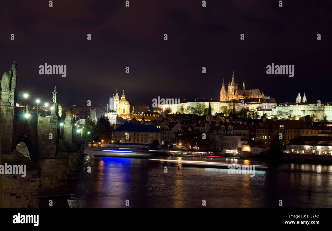 panoramic view Charles Bridge Vltava River Castle district with cruise ship night light streaks ...