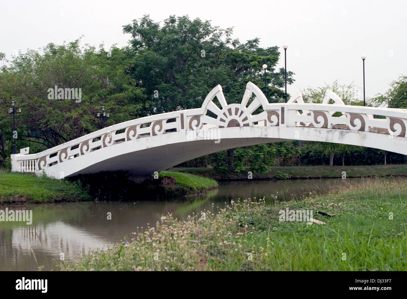 A beautiful footbridge that crosses a stream in a public park is part ...