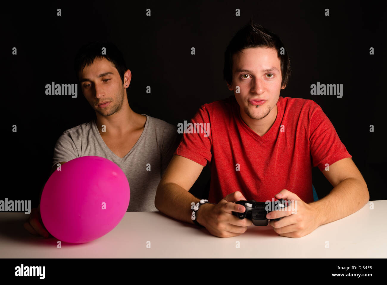 Two friends sitting together, one gaming the other bored, a concept ...