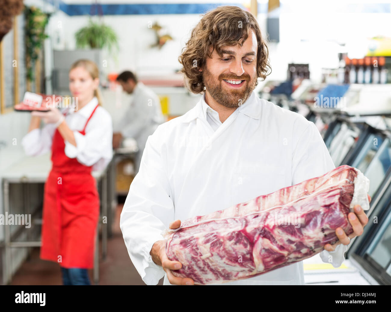 Happy Butcher Looking At Meat Package Stock Photo - Alamy