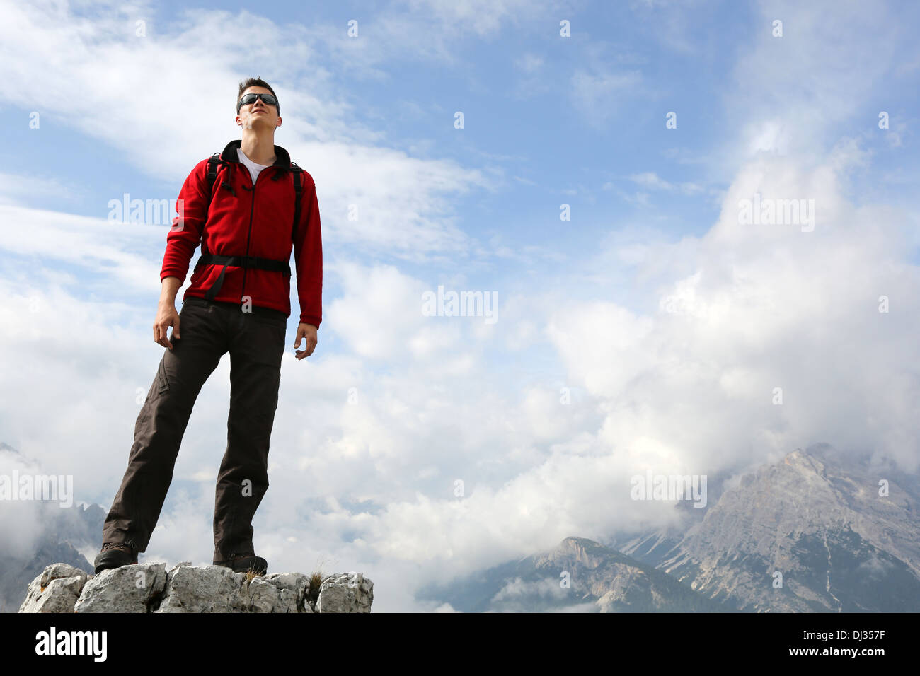 Young mountaineer standing on a mountain top and enjoying freedom in ...