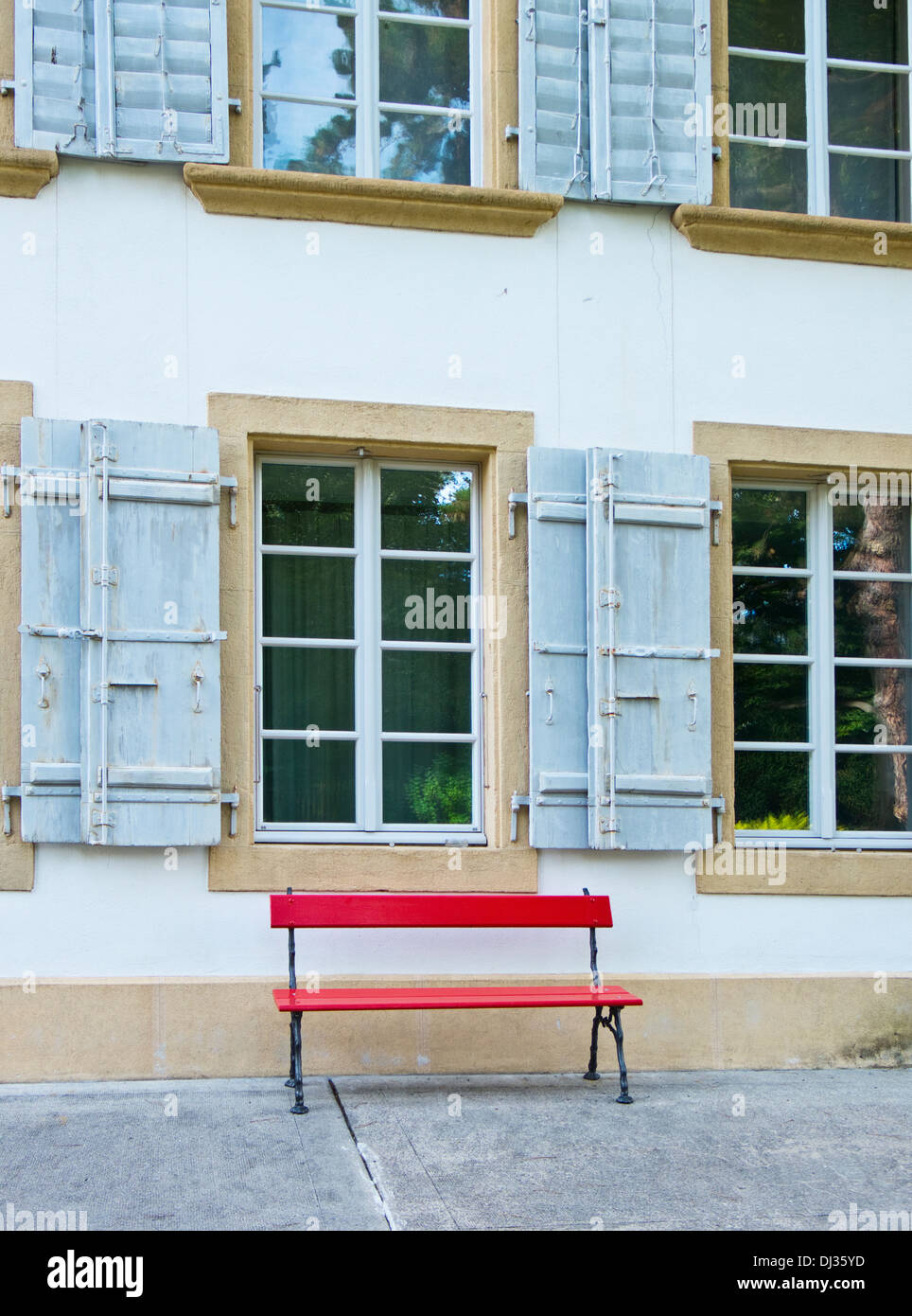 Red bench in front of building Stock Photo - Alamy