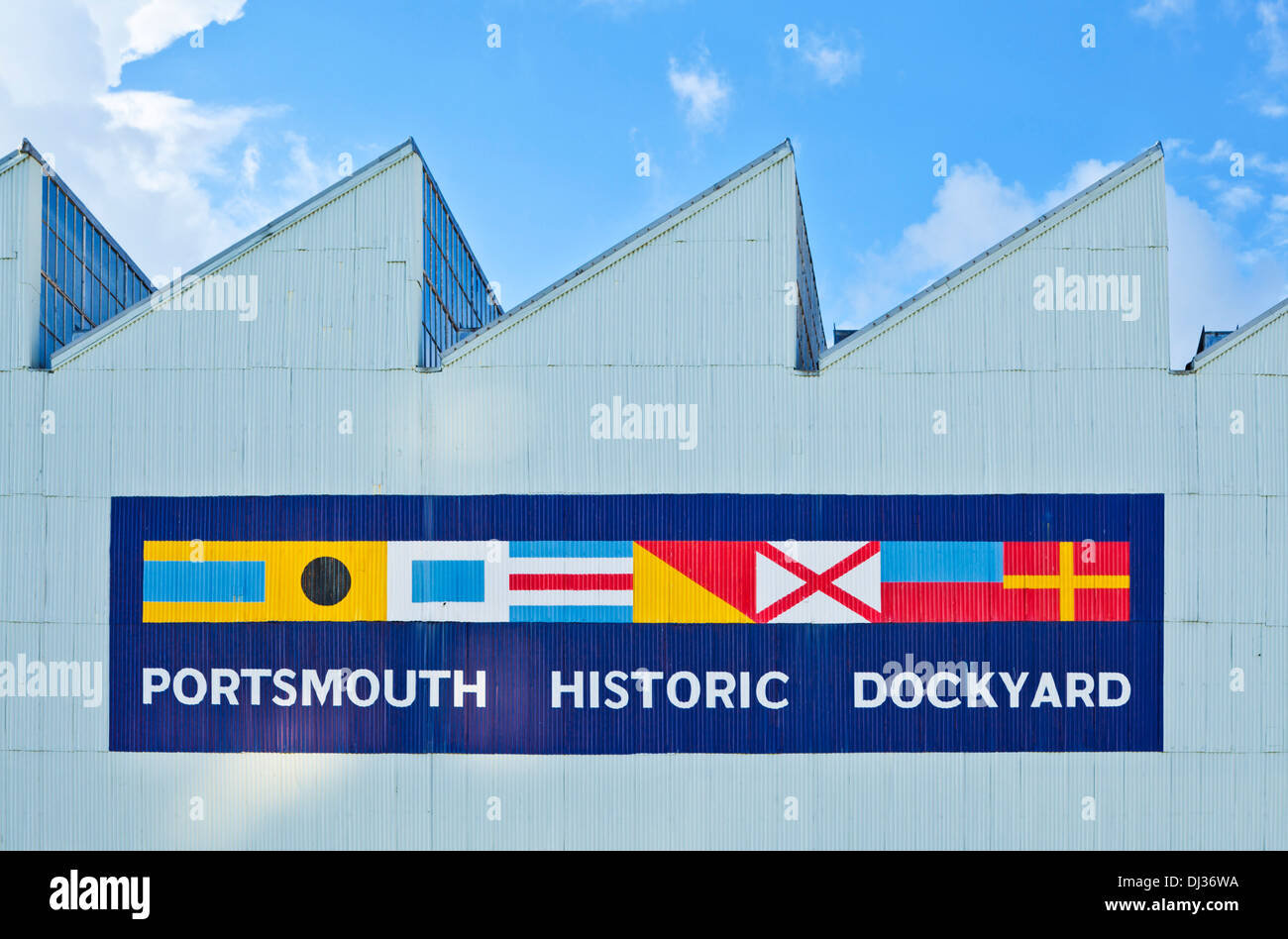 Portsmouth historic dockyard sign with flags on the side of a building ...