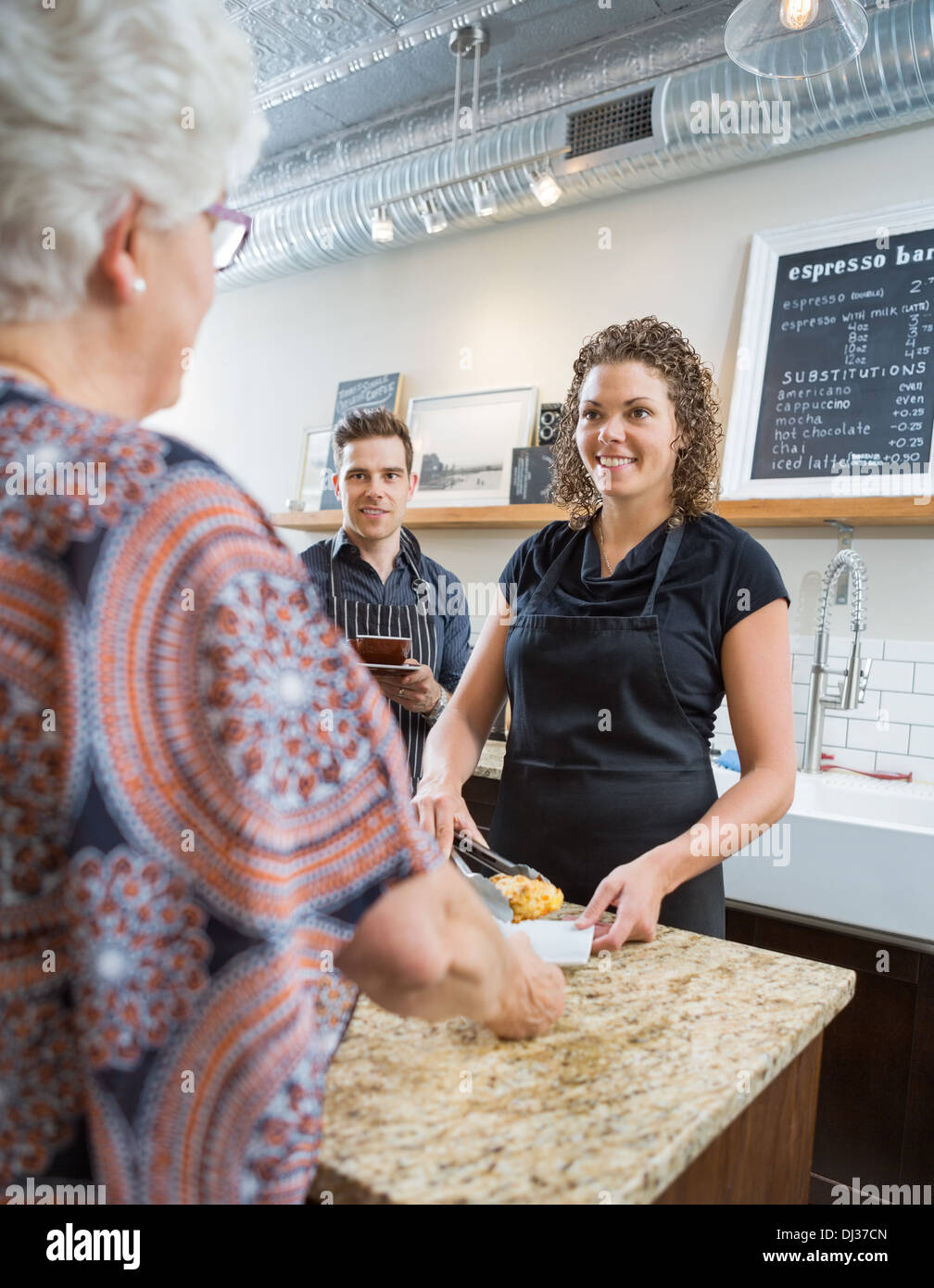 Workers Looking At Senior Woman In Cafeteria Stock Photo - Alamy