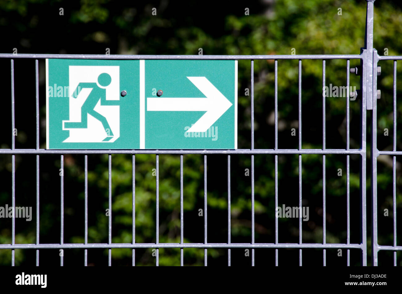 Green escape route sign on a metal fence Stock Photo - Alamy