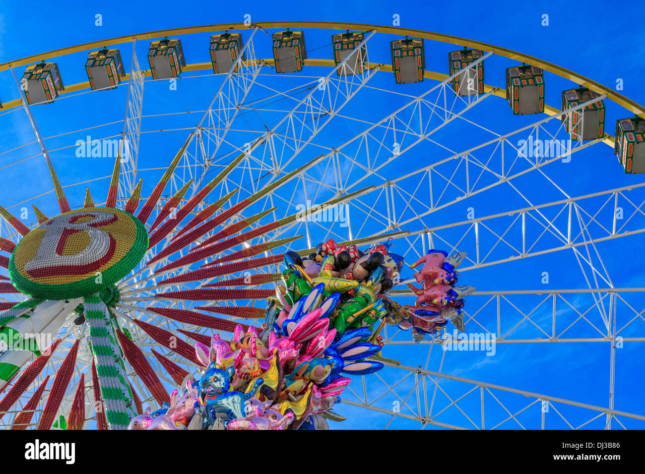 A photograph of a tower of balloons in front of a ferris wheel at the ...