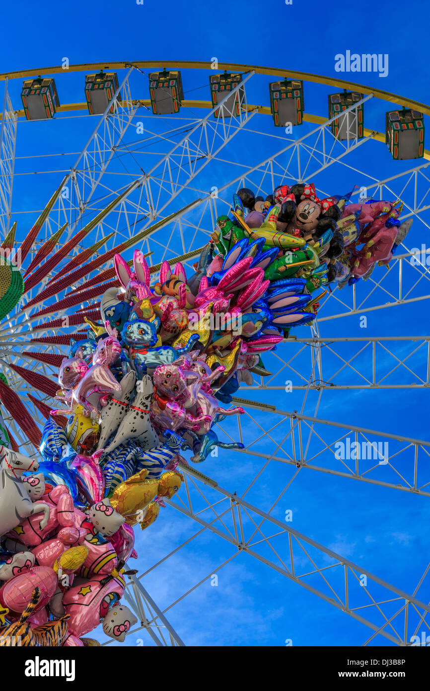 A photograph of a tower of balloons in front of a ferris wheel at the ...