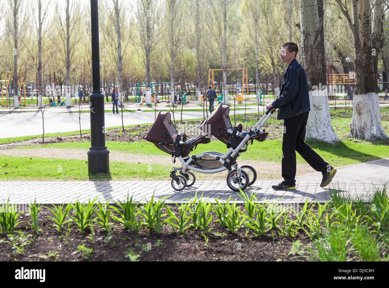 SAMARA, RUSSIA - MAY 3: Father with a baby stroller for twins walk in ...
