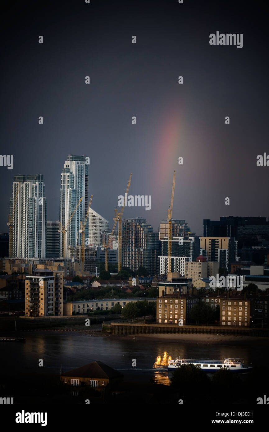 A colourful rainbow seen over River Thames towards the Isle of Dogs ...