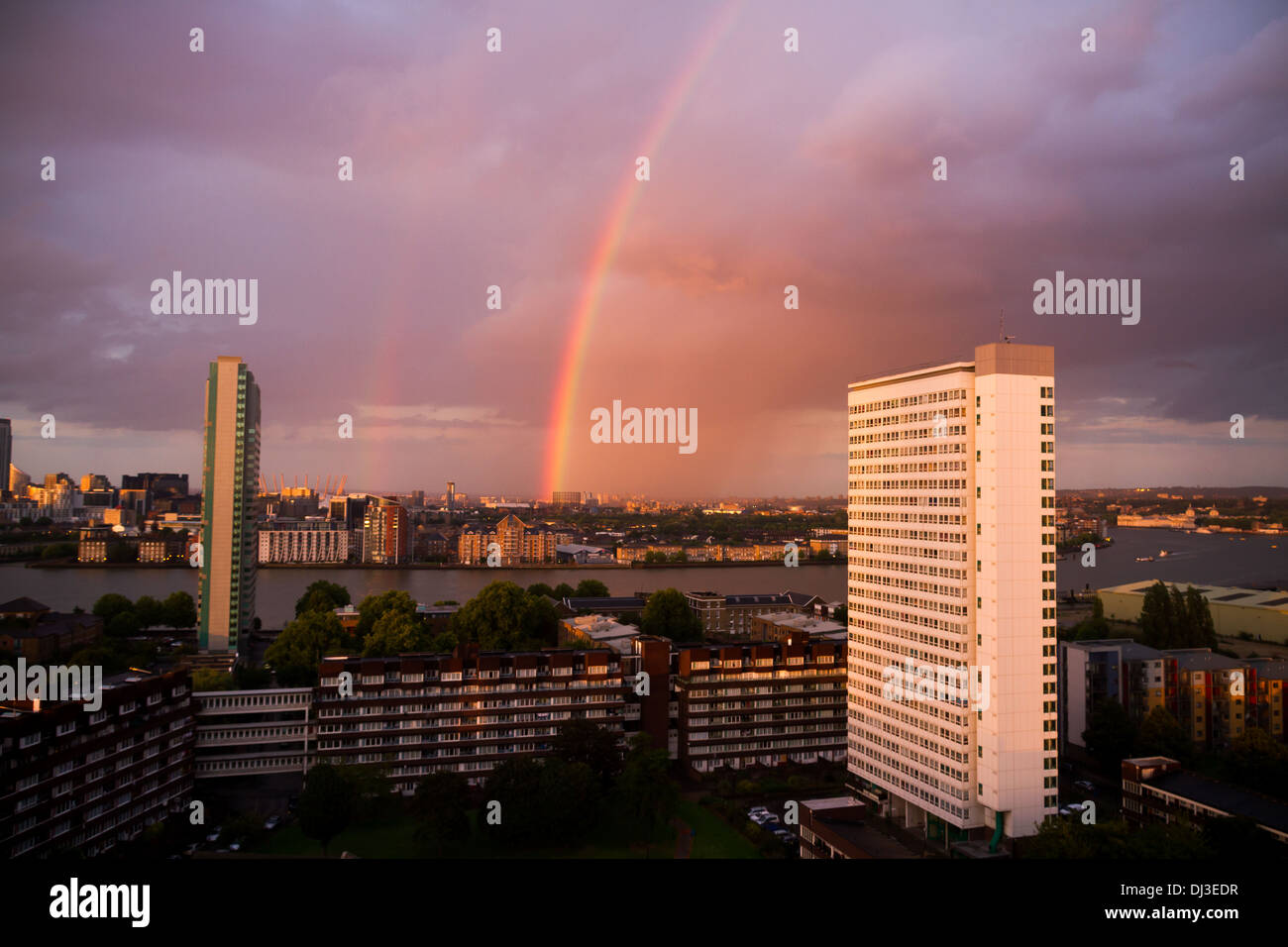 A colourful red evening rainbow arc breaks after a brief rainstorm over ...