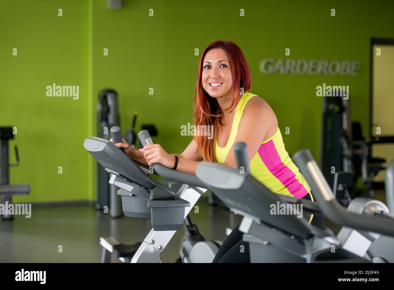 Beautiful woman exercising on an exercise bike Stock Photo - Alamy