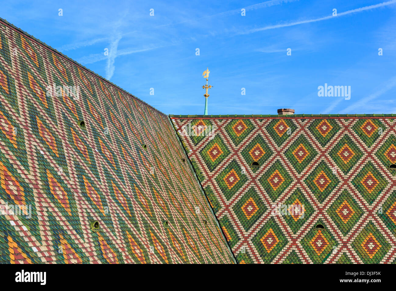 Green, red, and yellow roof tiles of the Basel Cathedral in Switzerland ...
