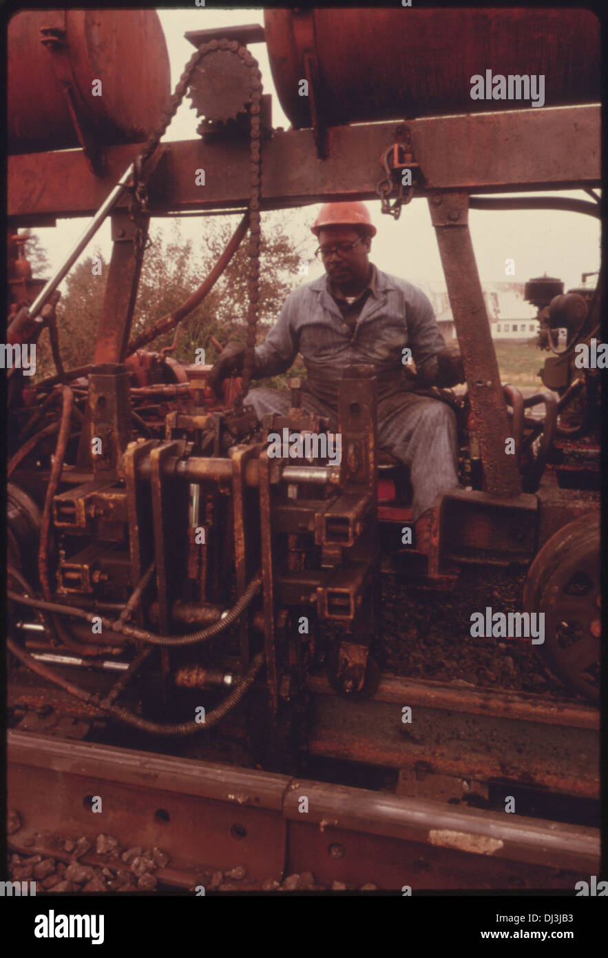 A Southern Railway repair worker operates a machine to position rails ...