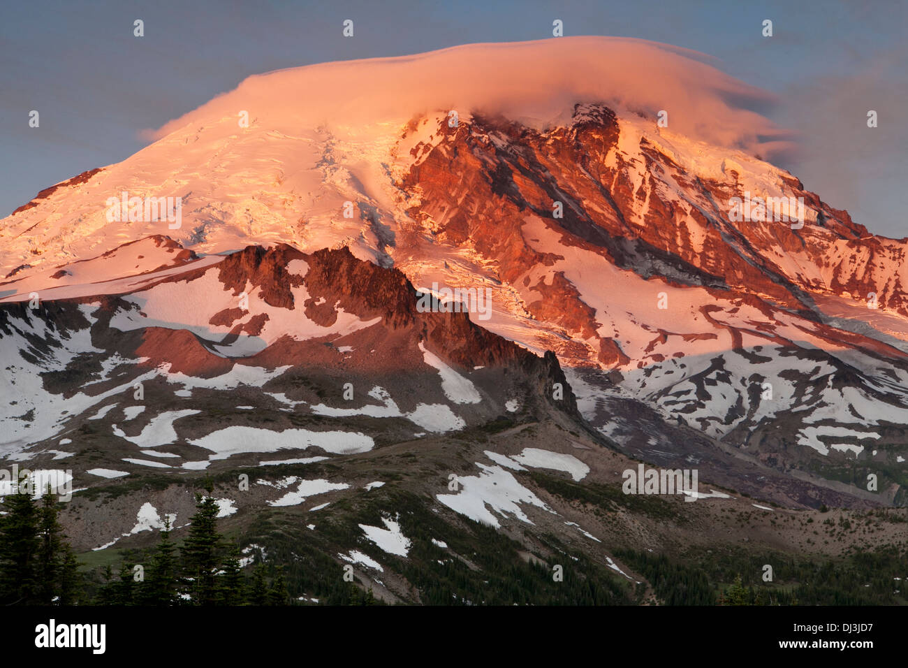 Mount Rainier at sunrise with a dramatic pink cloud cap partially ...