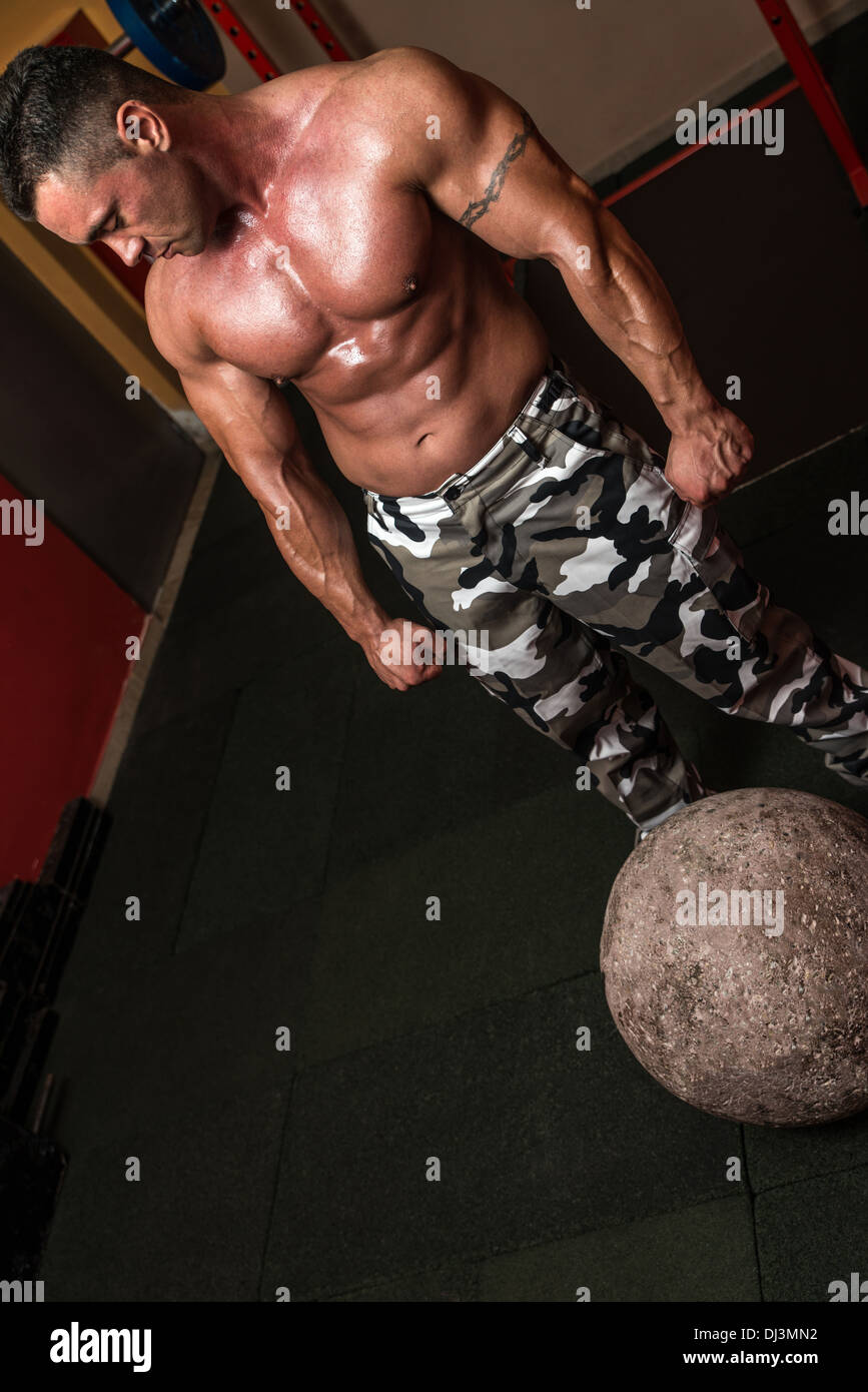 Bodybuilder Resting After Picking Up A Stone Stock Photo - Alamy