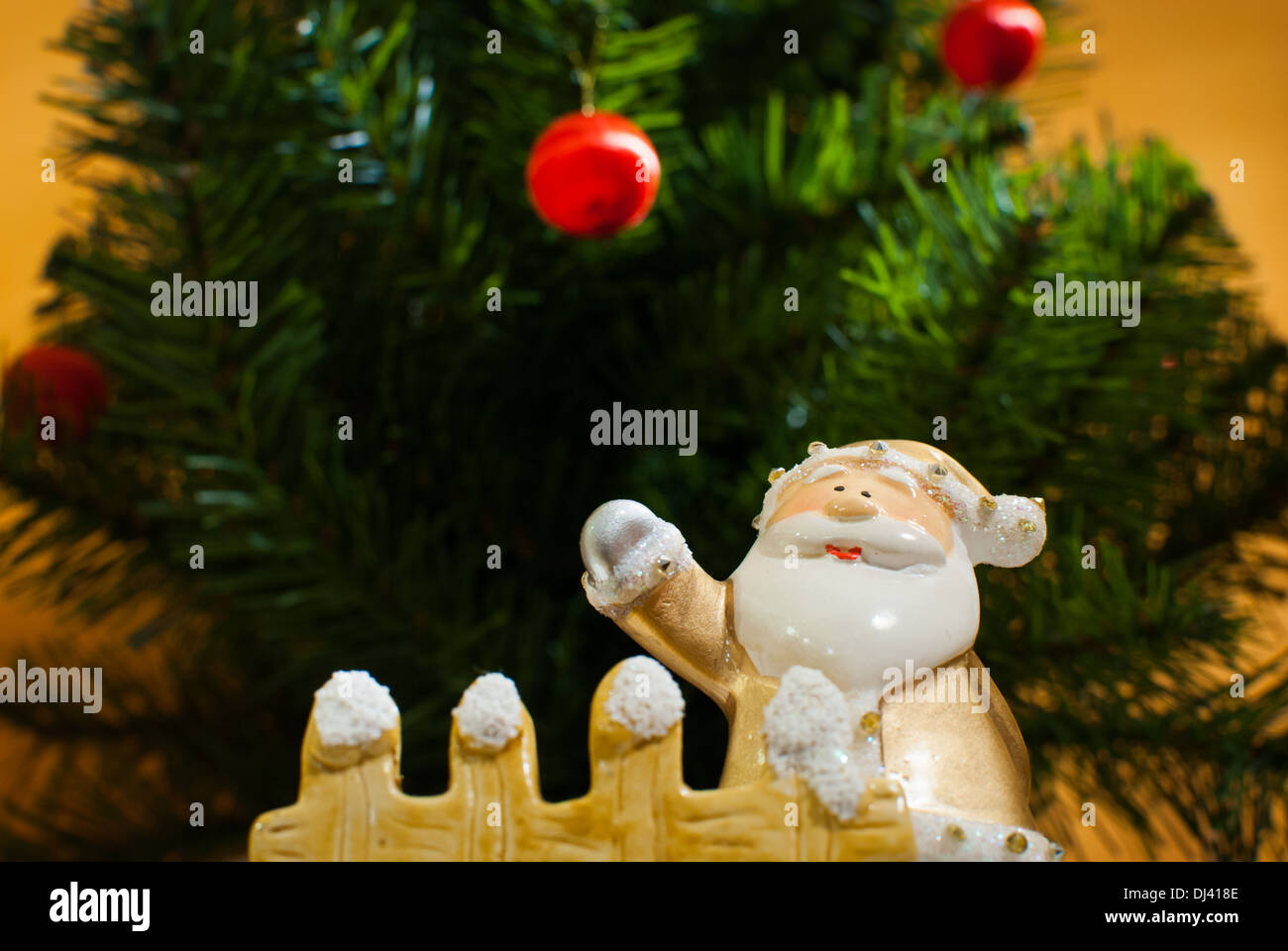 Yellow old time Santa Claus figurine standing behind garden fence and ...