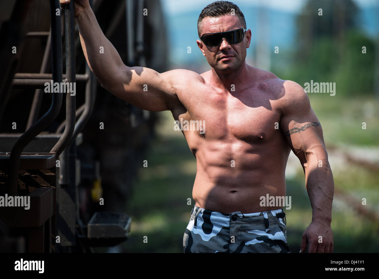 Man Athlete Holding On To Train Stock Photo - Alamy